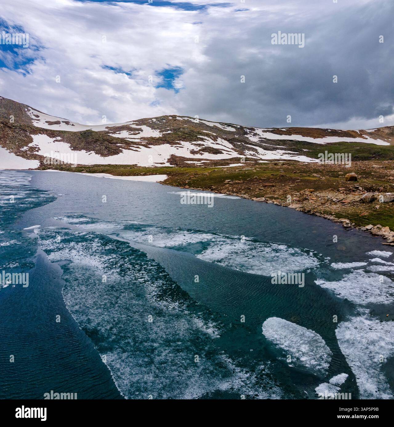 Aerial view of serene glacial lake surrounded by majestic snow-covered ...