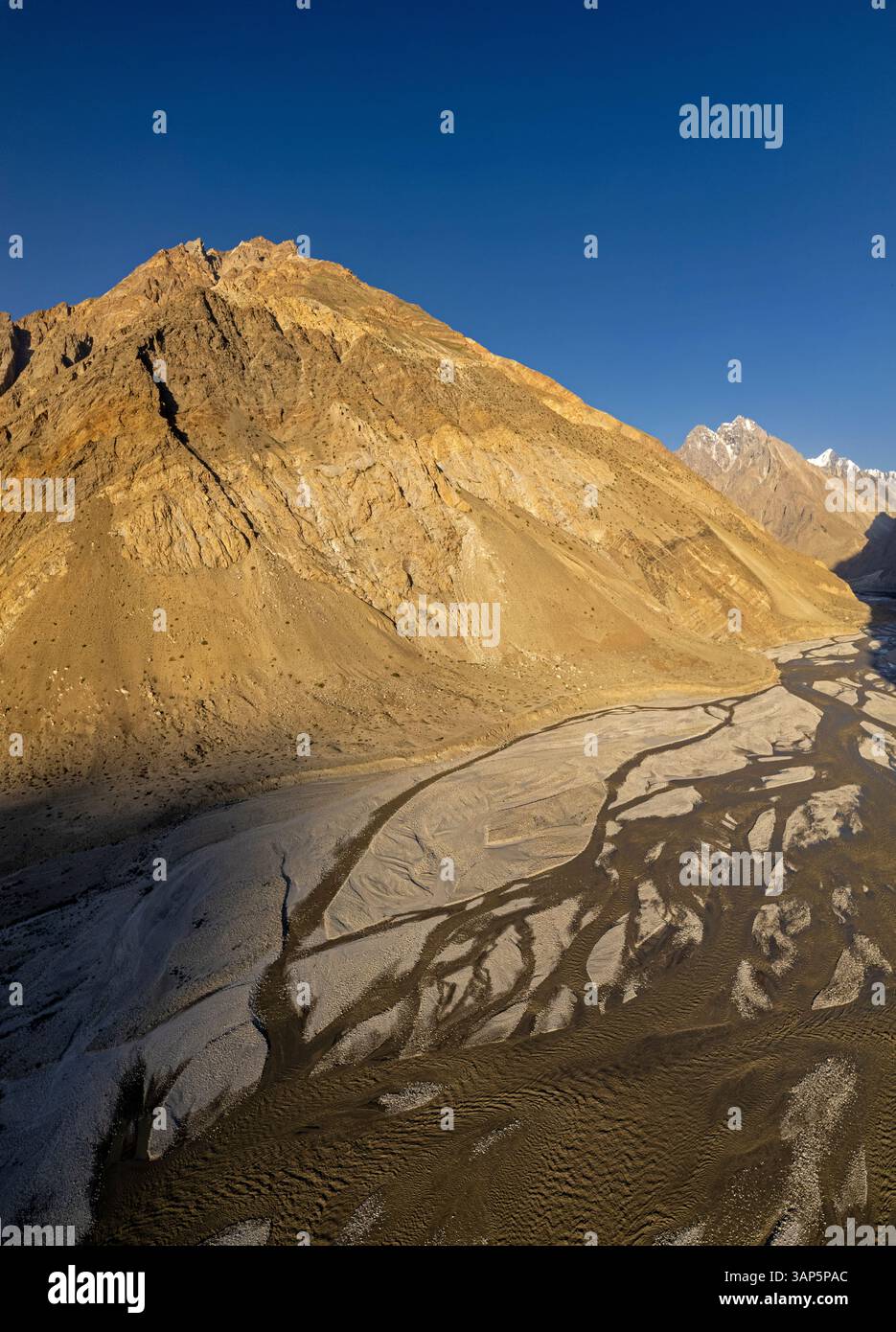 Aerial view of majestic mountains and a vast valley with a dry riverbed ...