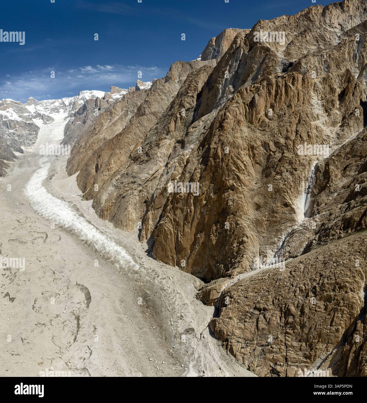 Aerial view of rugged snow-capped mountains and a pristine glacier in a ...