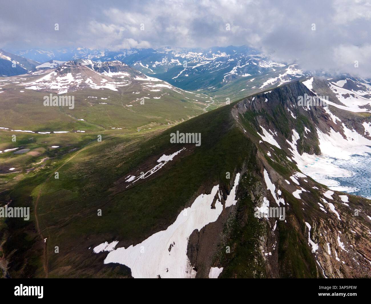 Aerial view of majestic snowy mountains under dramatic clouds ...