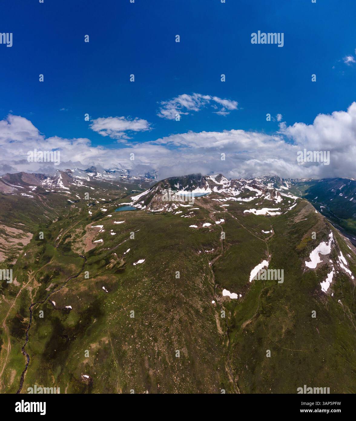 Aerial view of majestic snow-capped mountains under a dramatic sky with ...