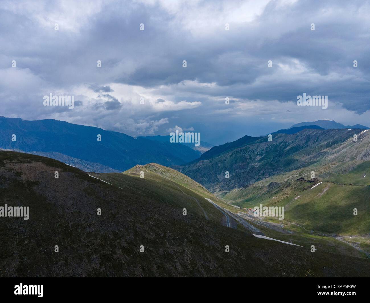 Aerial view of majestic mountains and a scenic valley under a cloudy ...