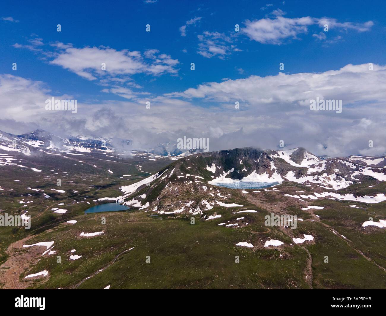 Aerial view of majestic mountains and a pristine lake under a dramatic ...