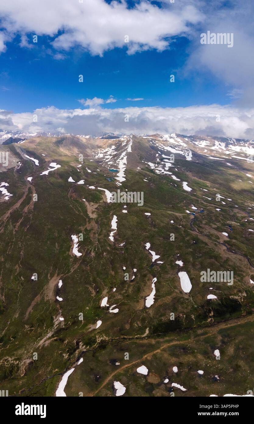 Aerial view of majestic snow-capped mountains under a serene sky with ...
