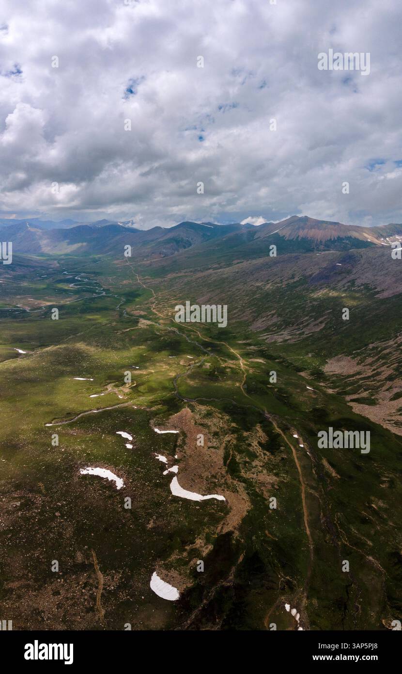 Aerial view of majestic mountains and a tranquil valley under a vast ...