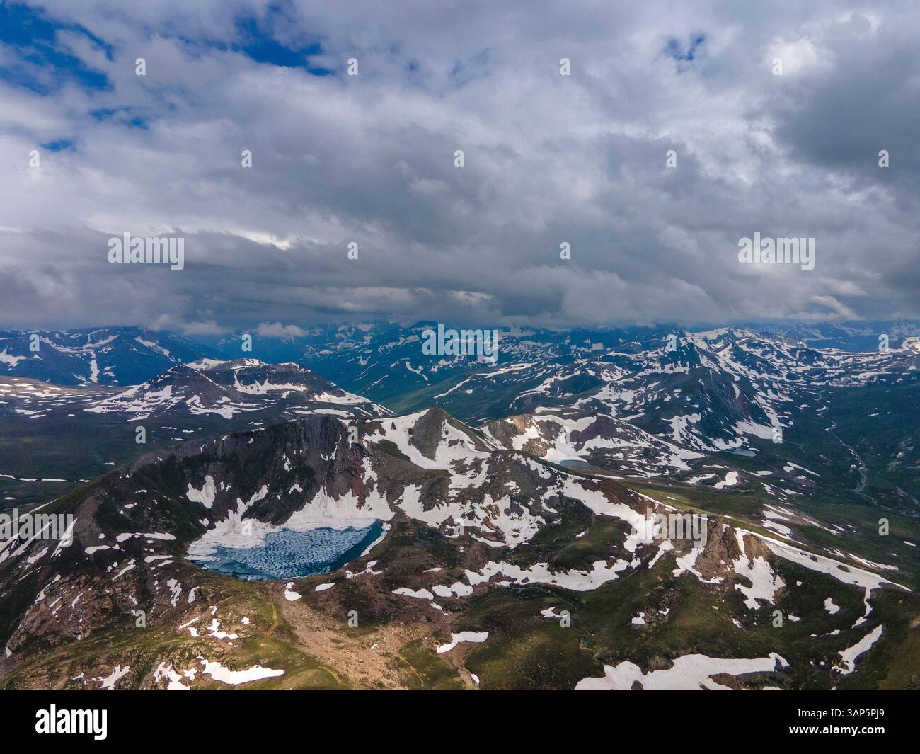 Aerial view of majestic snowy mountains under clouds in the scenic ...