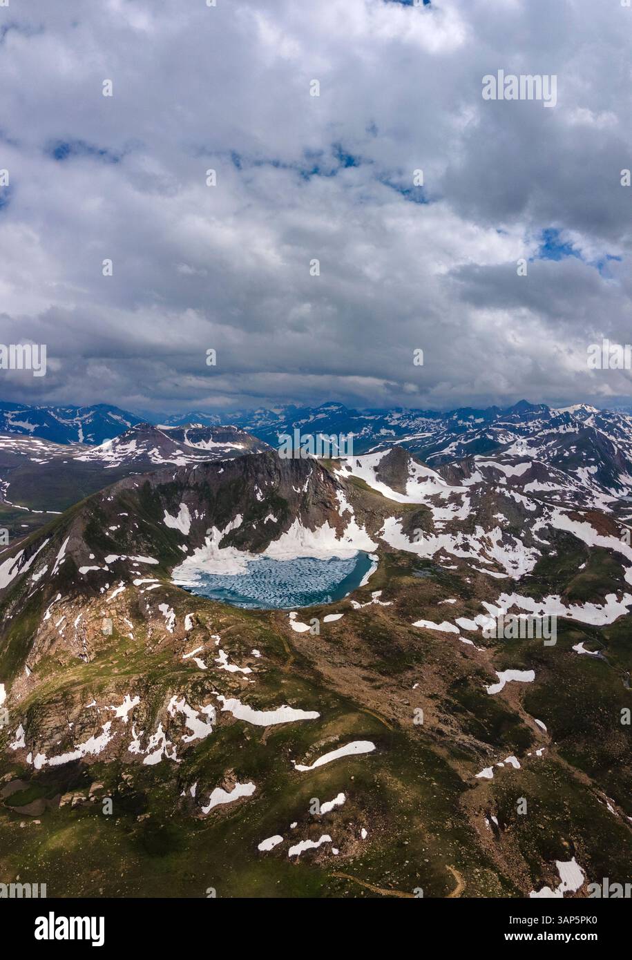 Aerial view of snowcapped mountains and a serene lake surrounded by ...