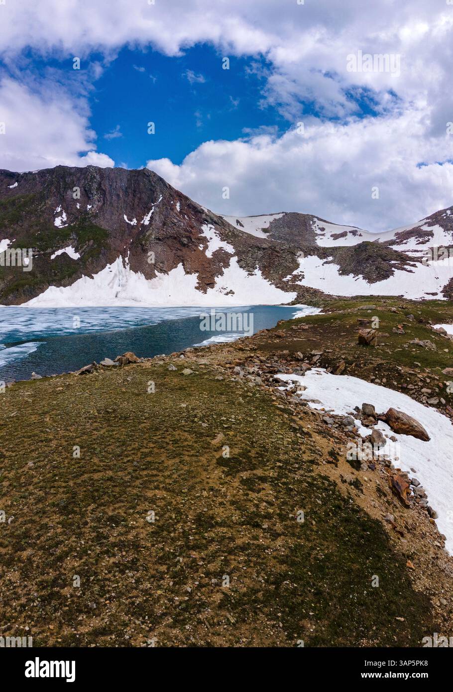 Aerial view of pristine snow-covered mountains and a serene lake under ...