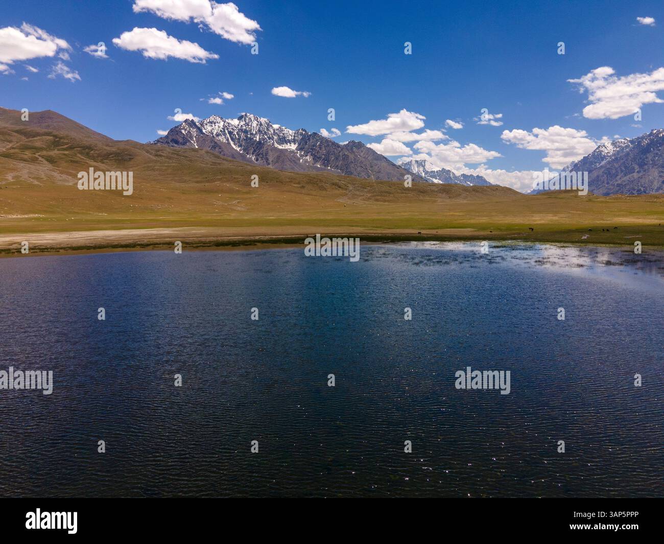 Aerial view of serene lake surrounded by majestic mountains under a ...
