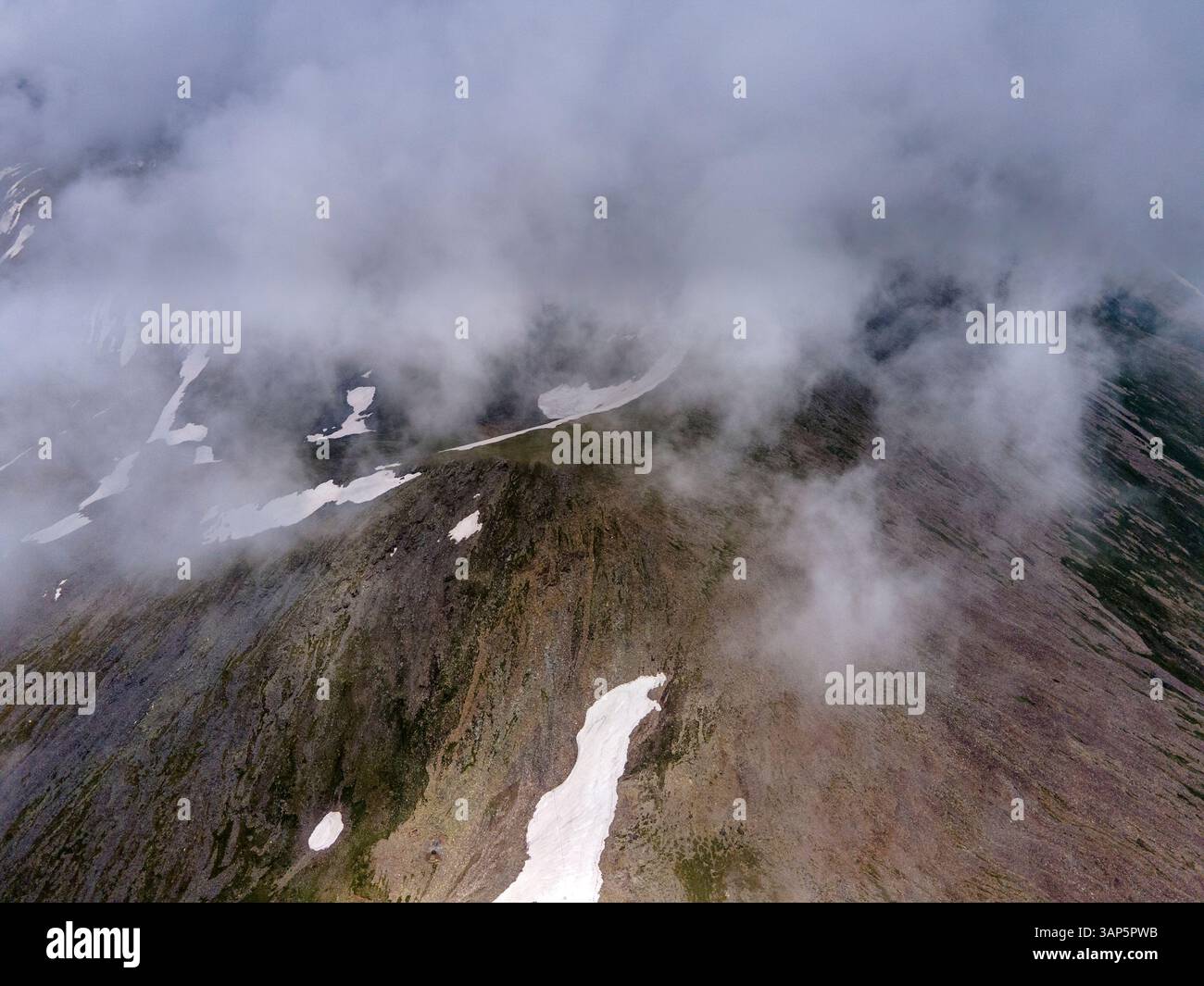 Aerial view of majestic snowy mountains under cloudy skies at Babusar ...