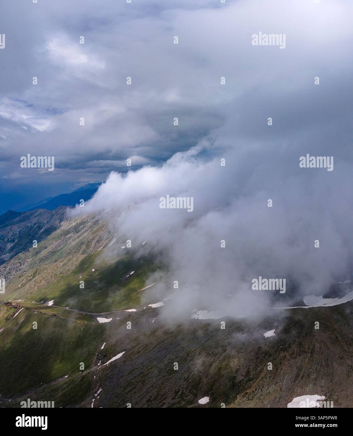 Aerial view of majestic snowy mountains and clouds over Babusar Pass ...