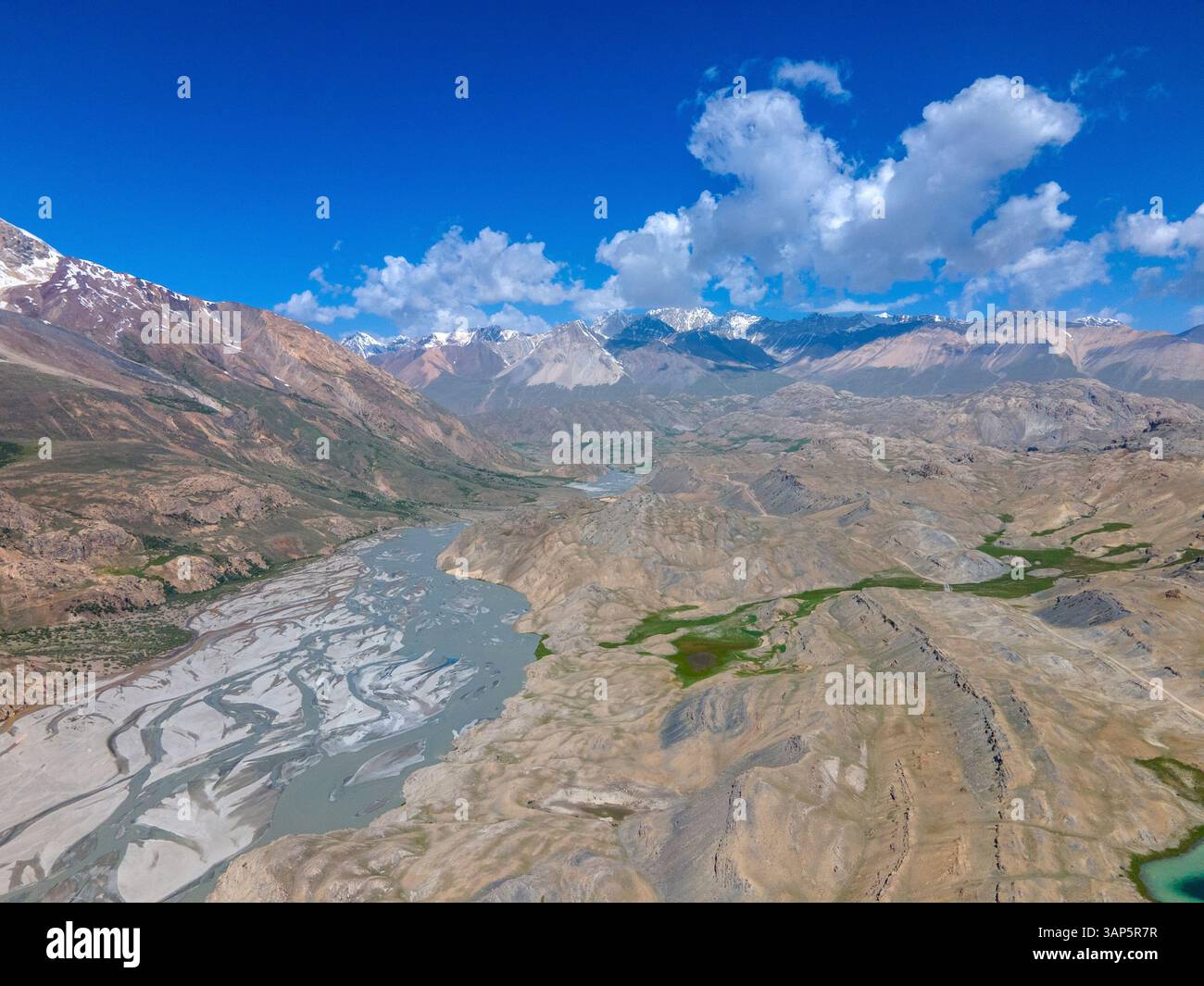 Aerial view of pristine snow-capped mountains and a serene river ...