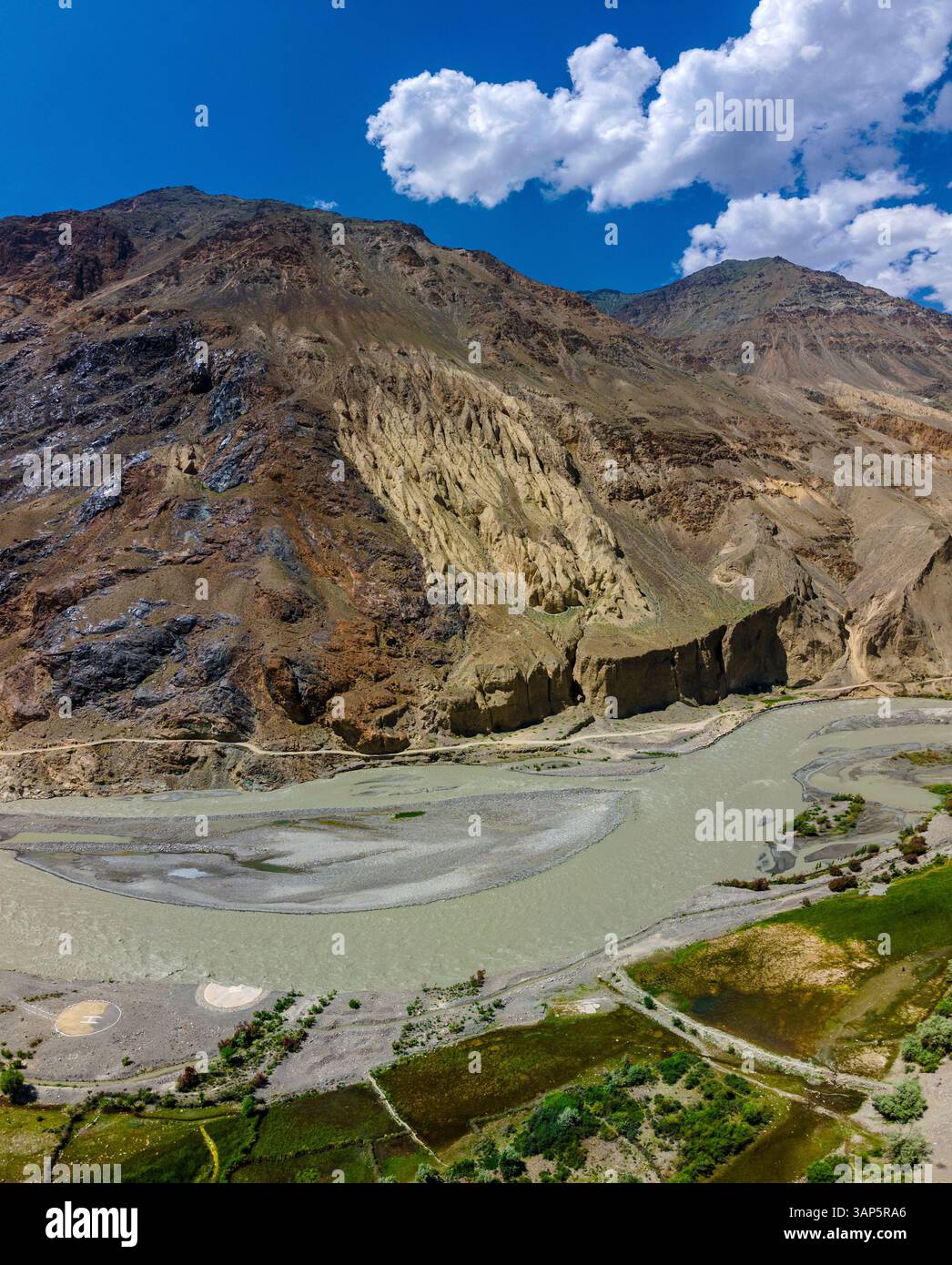 Aerial view of majestic mountains and a serene river winding through a ...