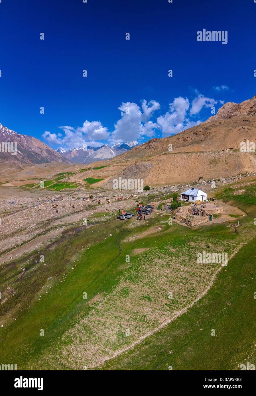 Aerial view of beautiful snow-capped mountains and a serene village in ...