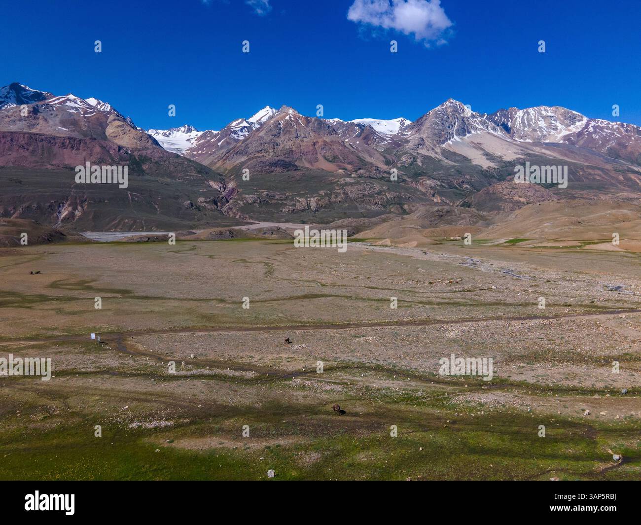 Aerial view of majestic mountains and serene valleys under a beautiful ...