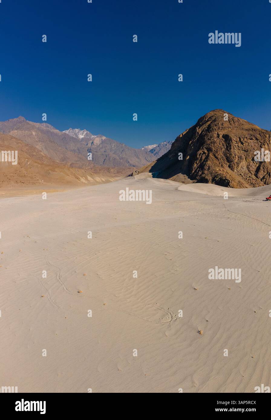 Aerial view of sarfaranga desert with majestic mountains and clear sky ...