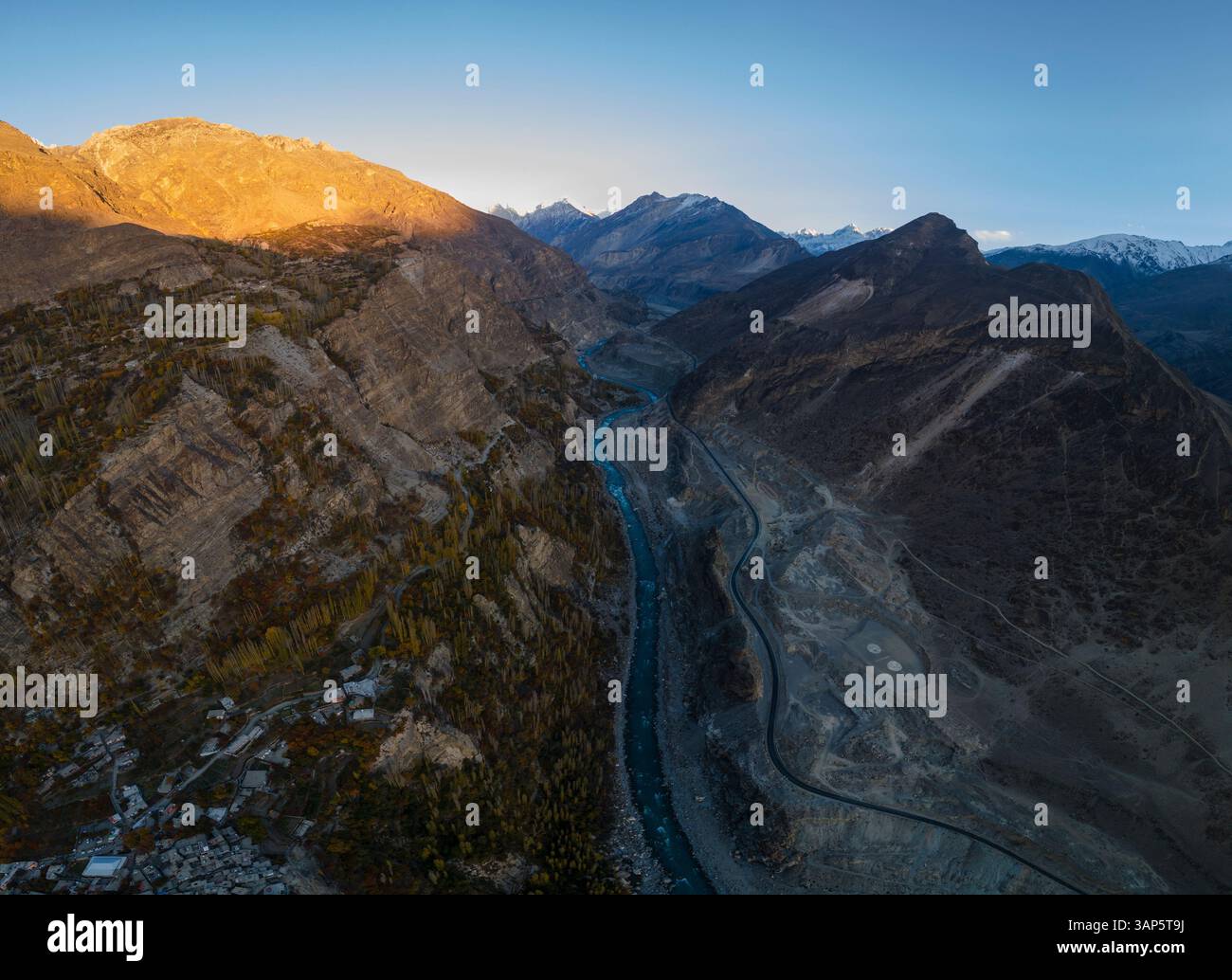 Aerial view of majestic mountains, river, and valley at sunset in Hunza ...