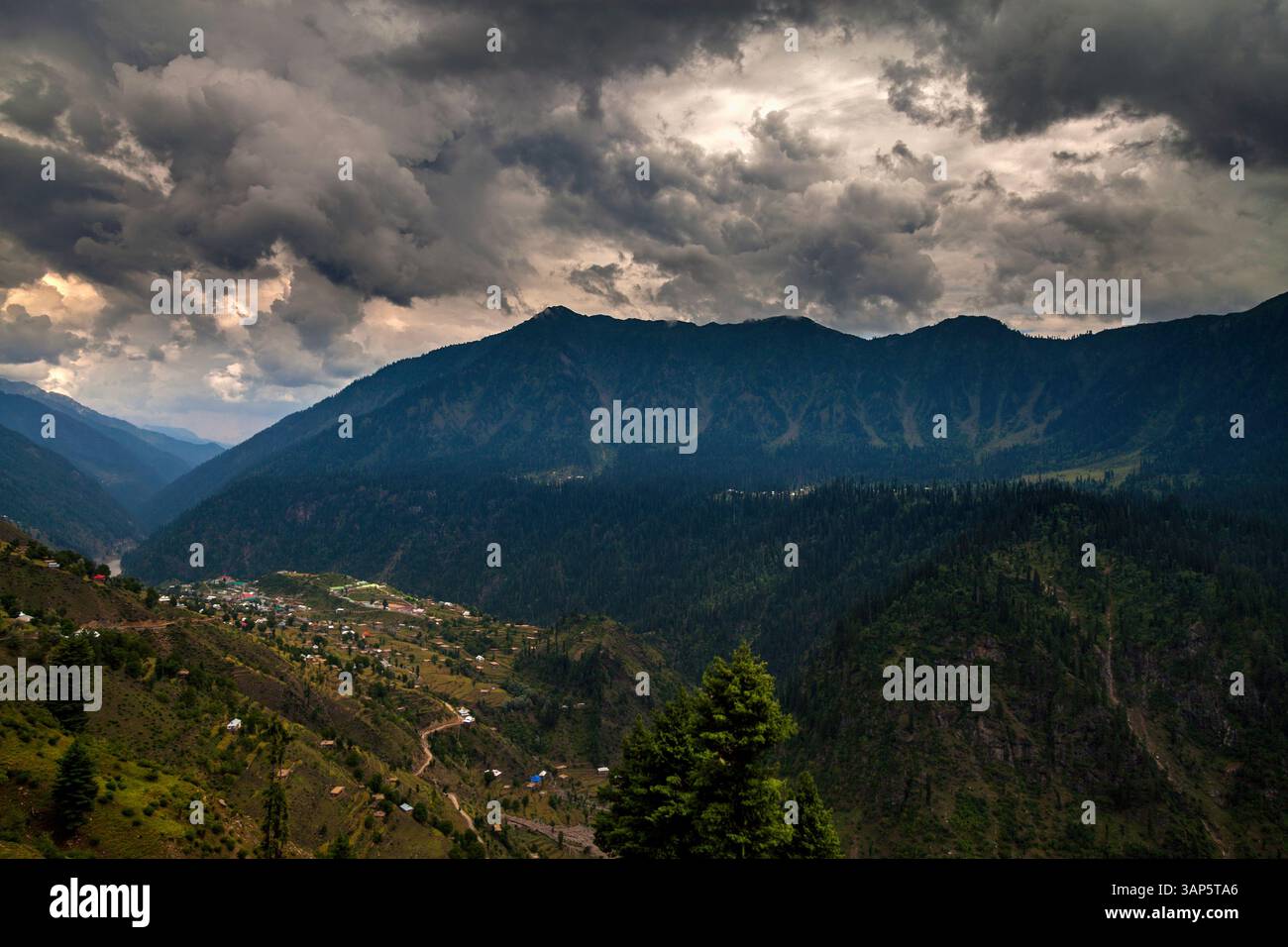 Aerial view of dramatic cloudy valley with lush green hills and remote ...
