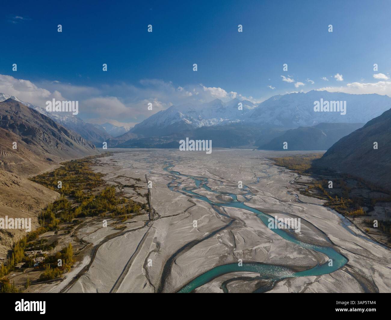 Aerial view of snow-covered mountains and meandering river in Machulo ...