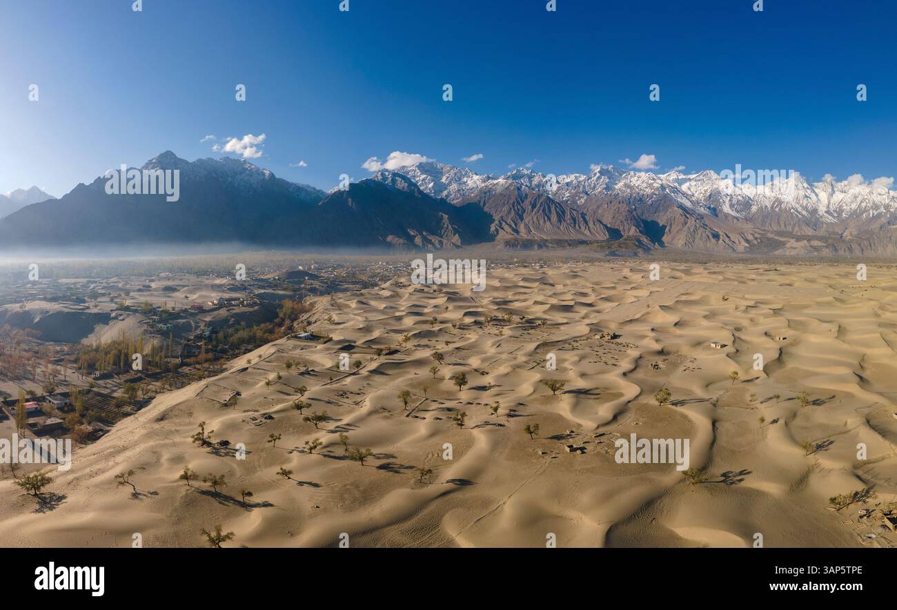 Aerial view of vast, barren desert with snowcapped mountains and sand ...