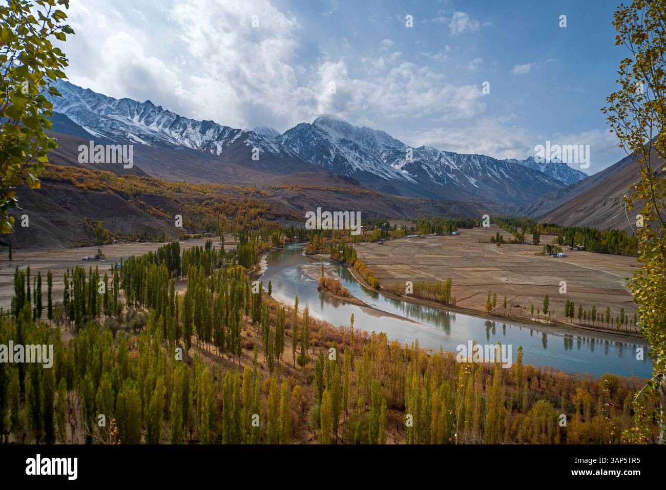 Aerial view of serene river winding through snow-capped mountains and ...