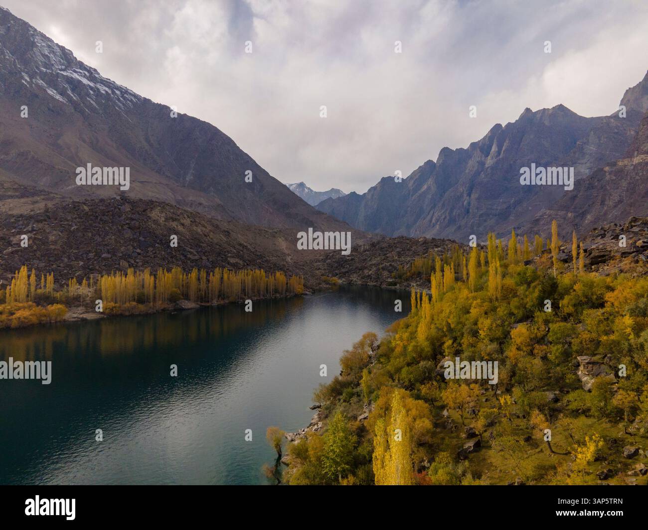 Aerial view of serene lake surrounded by majestic mountains and lush ...
