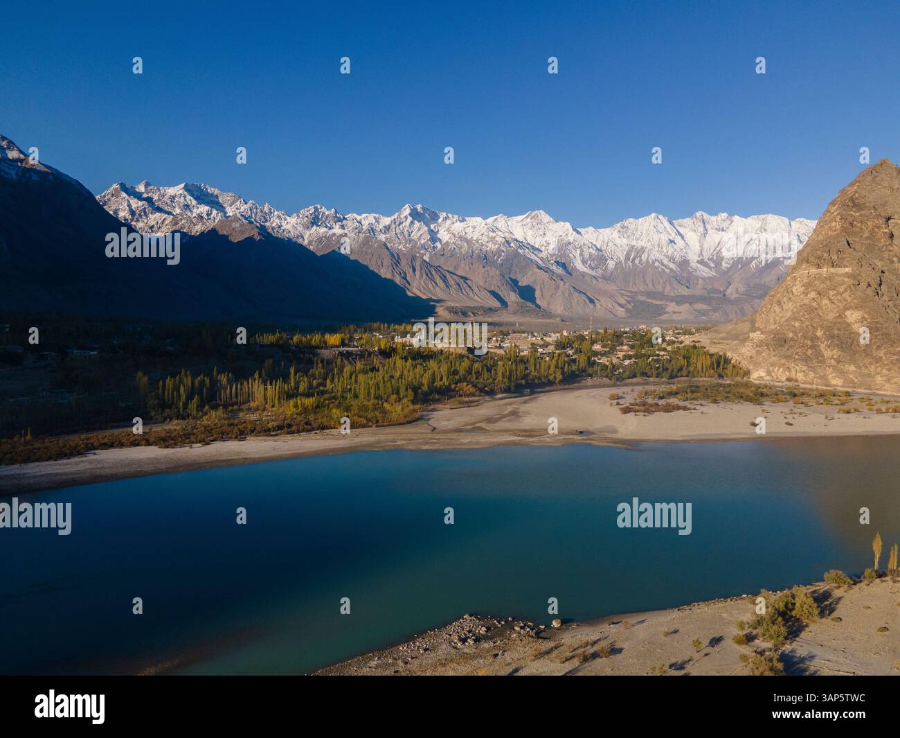 Aerial view of snow-capped mountains and Indus River in serene valley ...