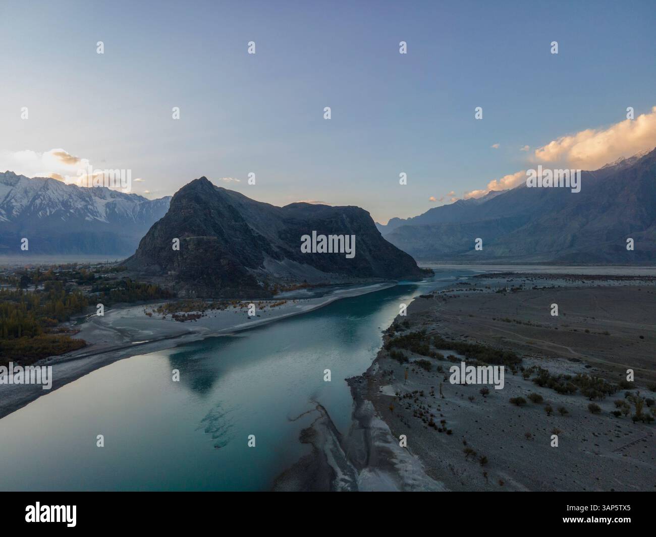 Aerial view of serene Indus River at sunset with majestic mountains ...