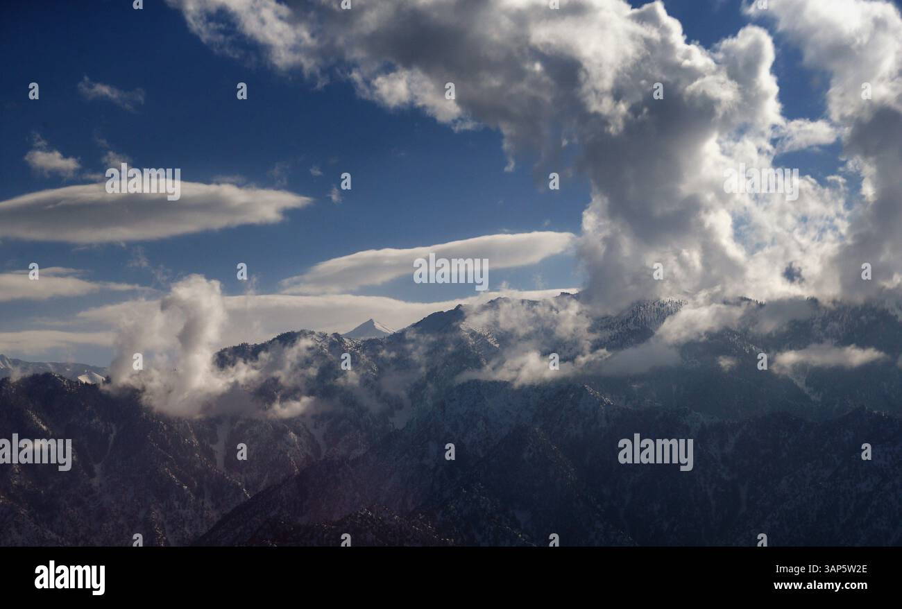 Aerial view of snowy mountains and cloudy sky in Kashmir region ...