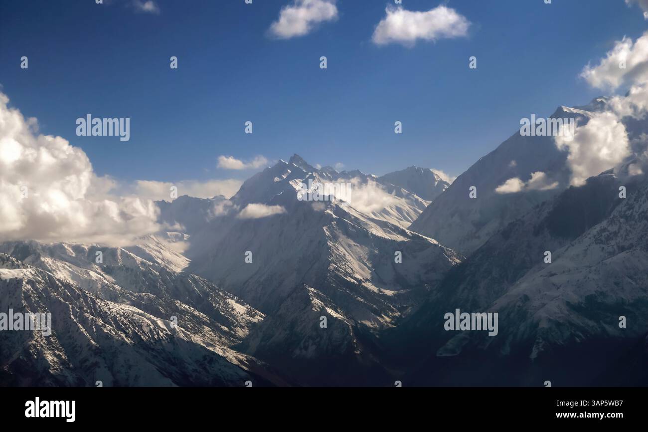 Aerial view of snowy mountains and clouds in Kashmir region, Pakistan ...