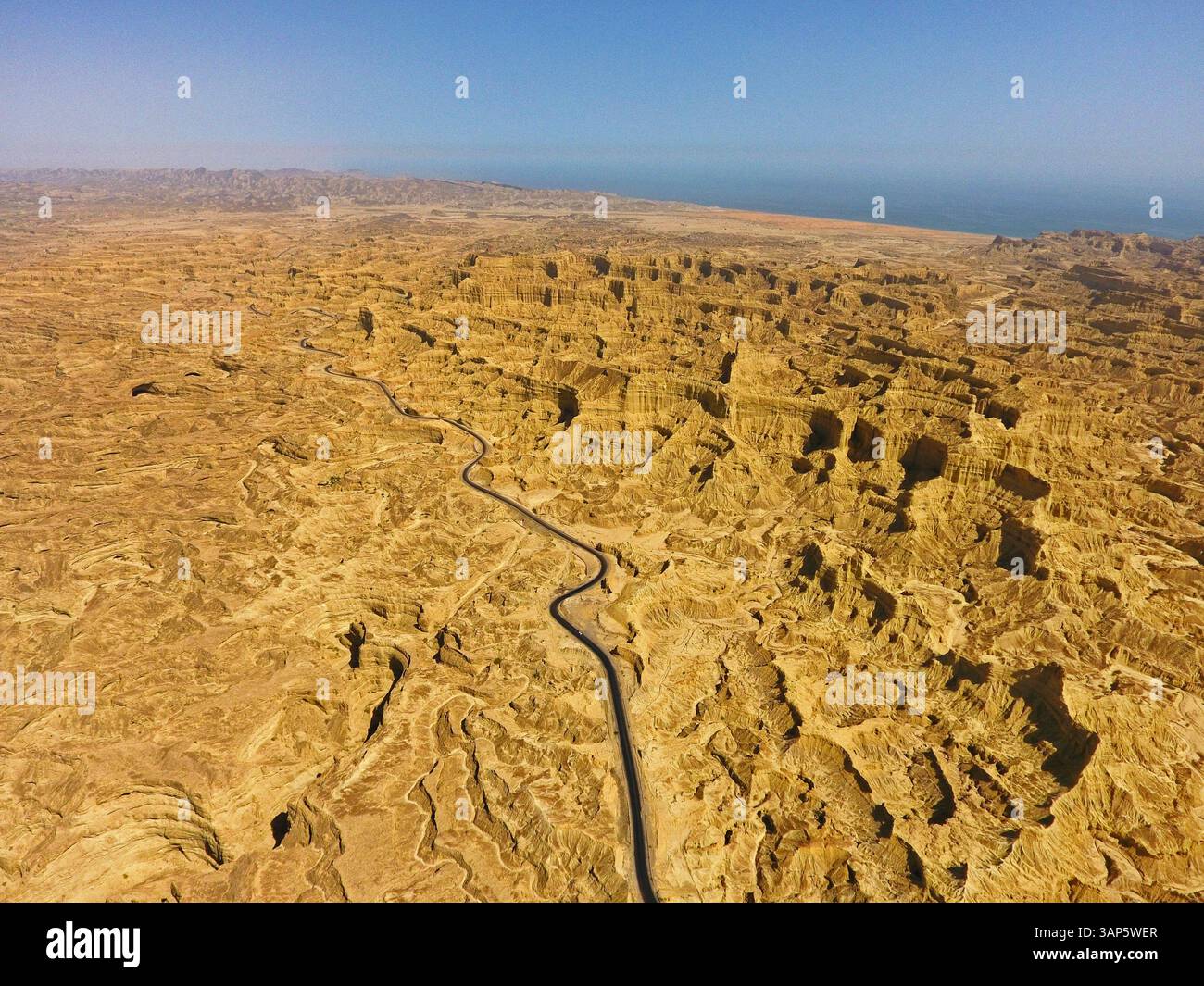 Aerial view of winding road through remote, rugged desert mountains ...