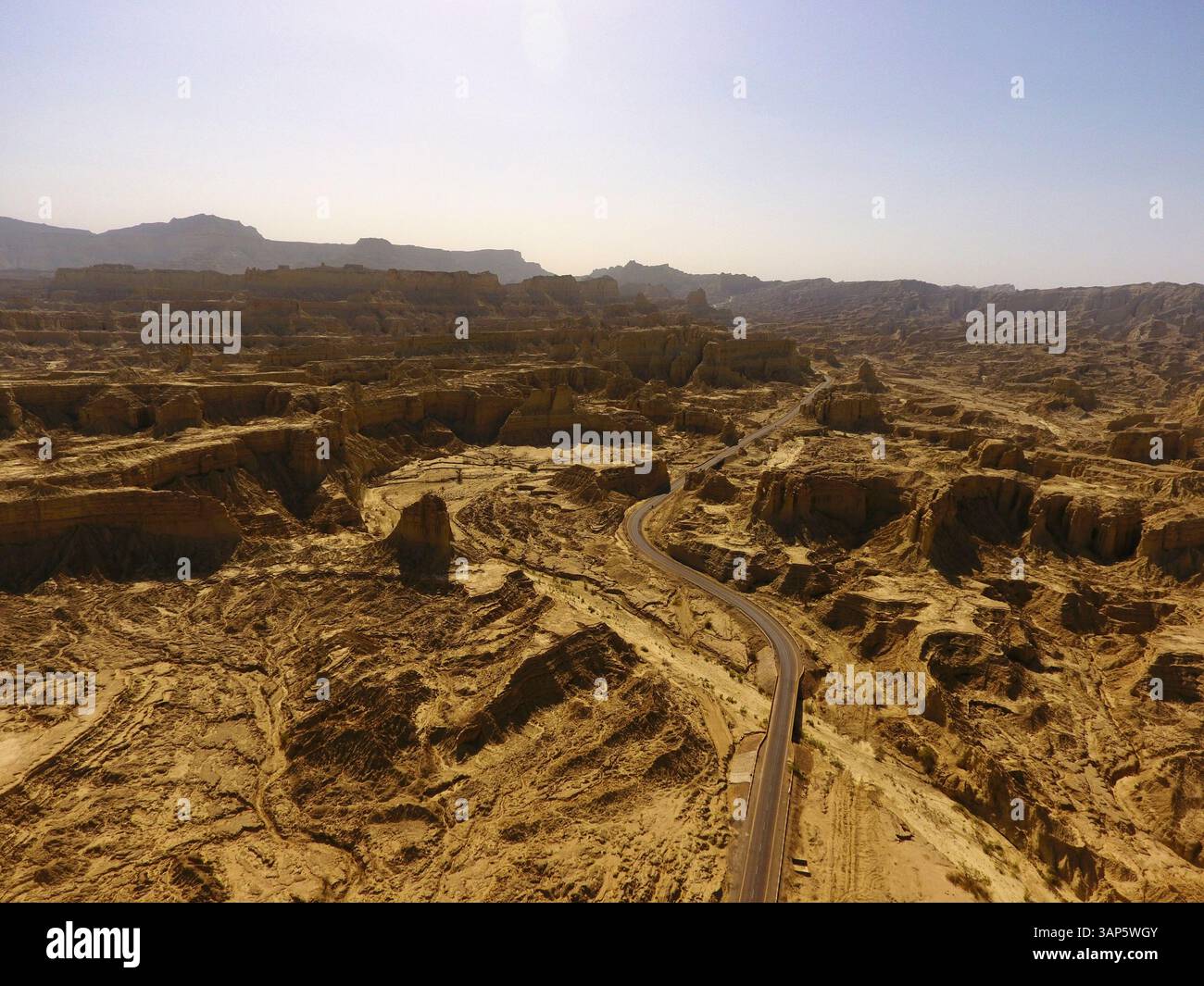 Aerial view of barren desert terrain with rugged mountains and winding ...