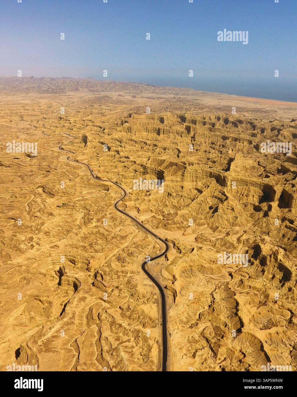 Aerial view of barren desert landscape with road cutting through remote ...