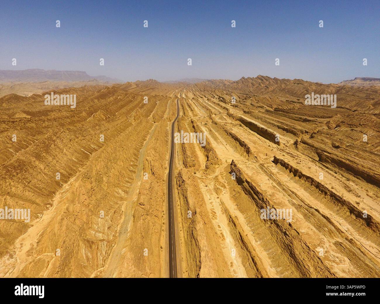 Aerial view of desert landscape with road cutting through rocky terrain ...