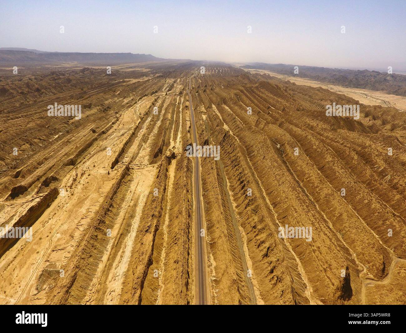 Aerial view of desert road winding through majestic mountains and hills ...
