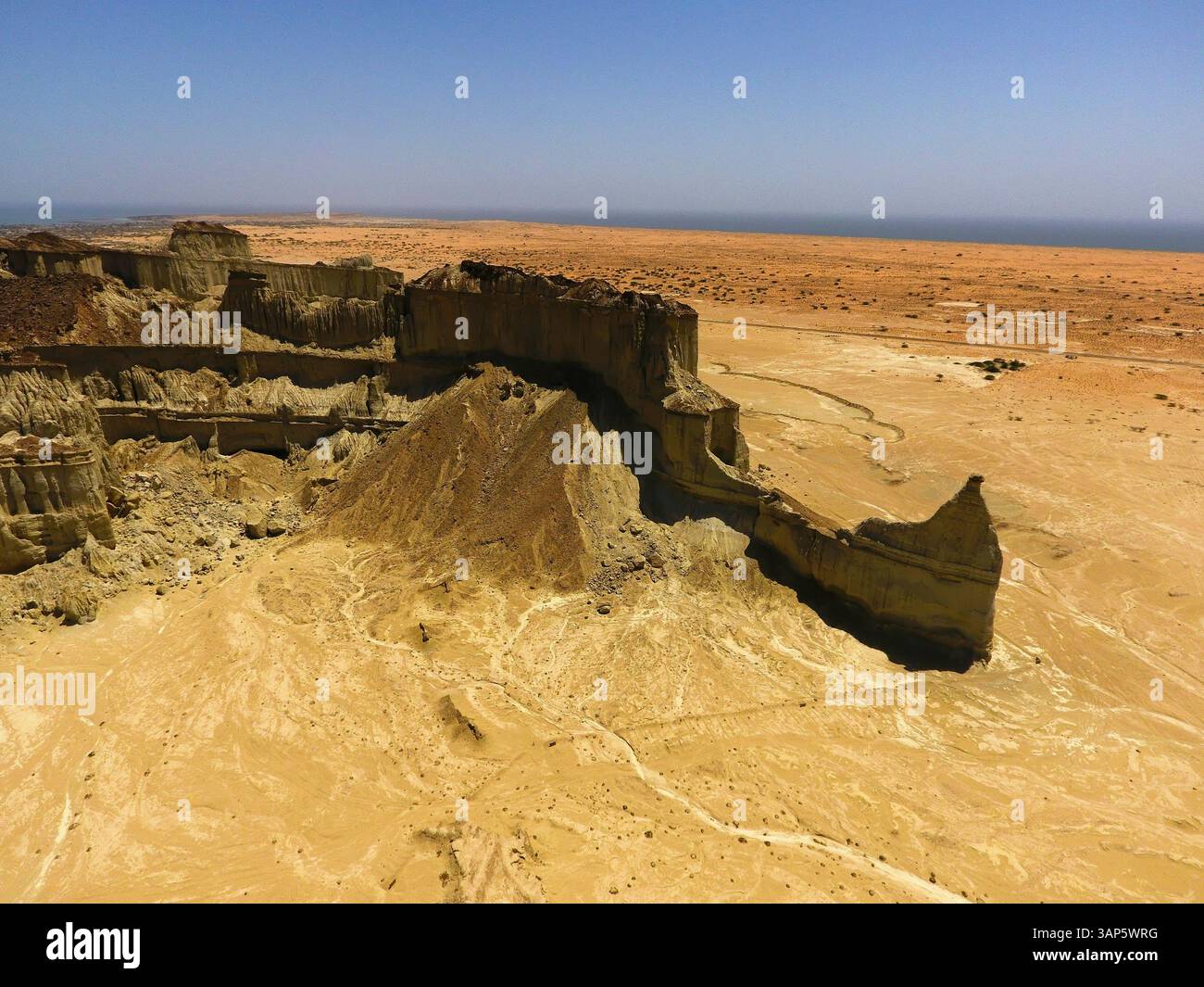 Aerial view of rugged desert canyon with rocky cliffs and sandy dunes ...