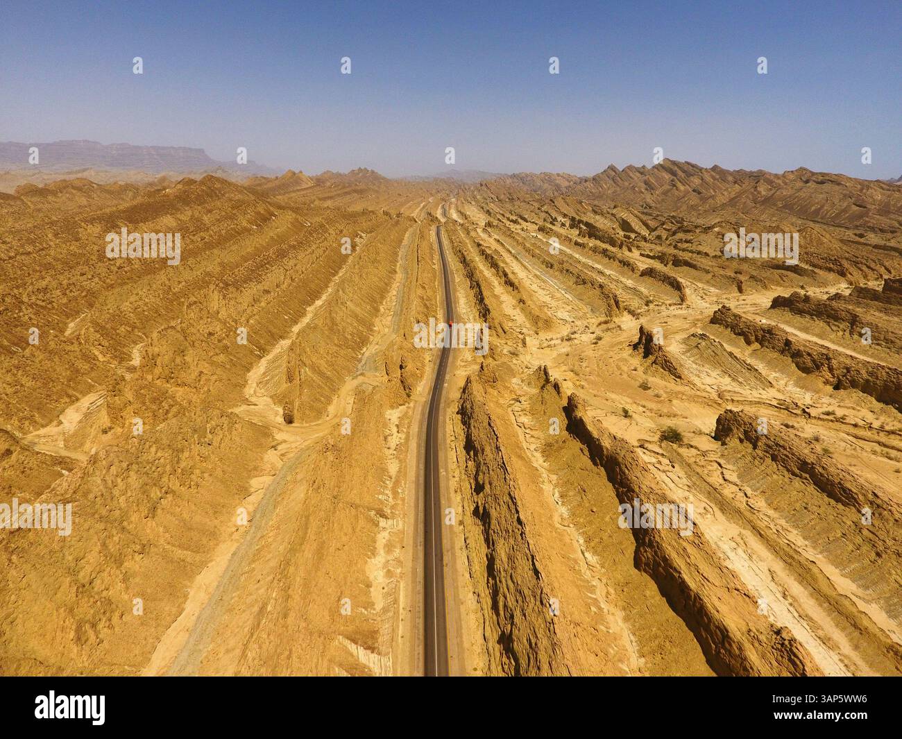 Aerial view of rugged desert terrain with road cutting through ...