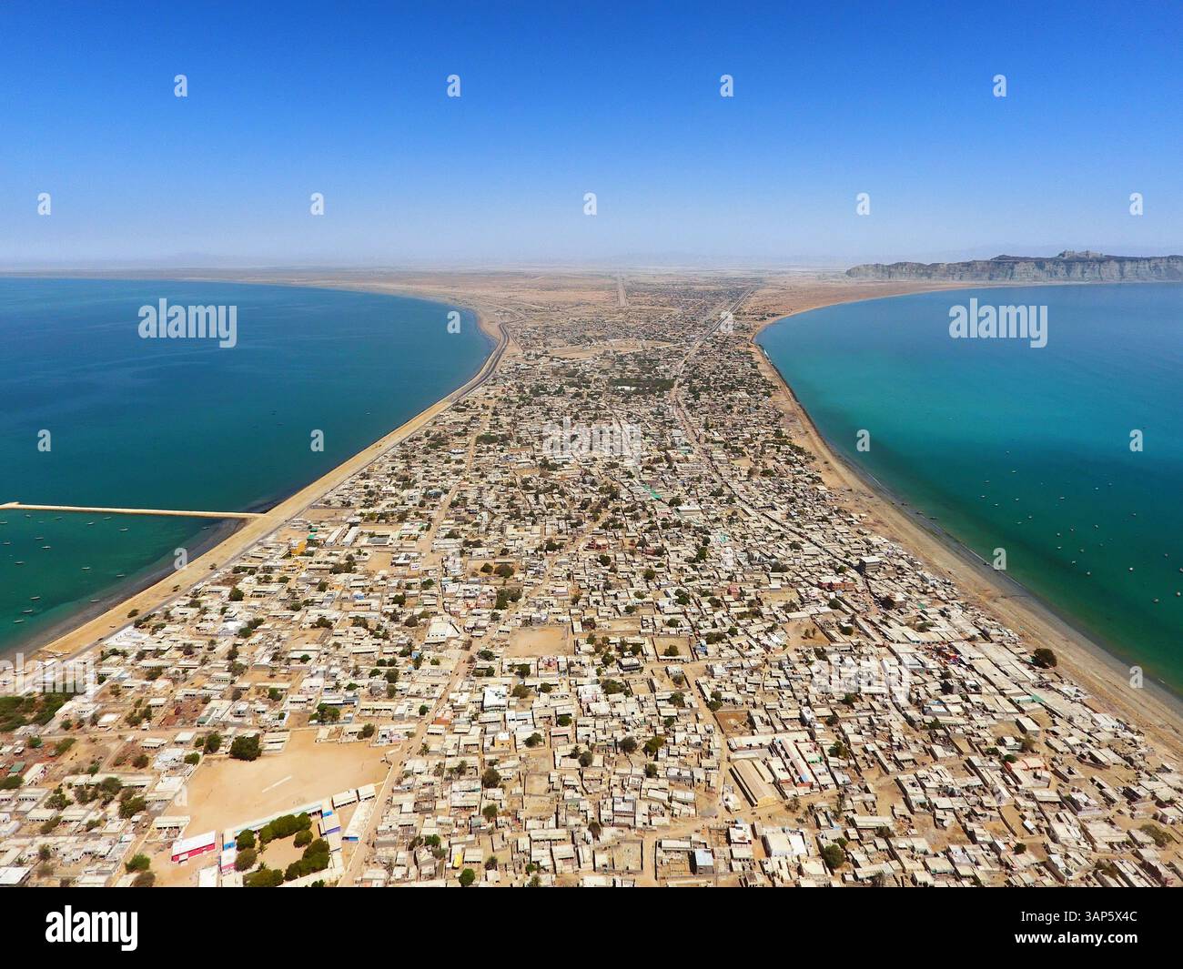 Aerial view of coastal cityscape with ocean and peninsula in Gwadar ...