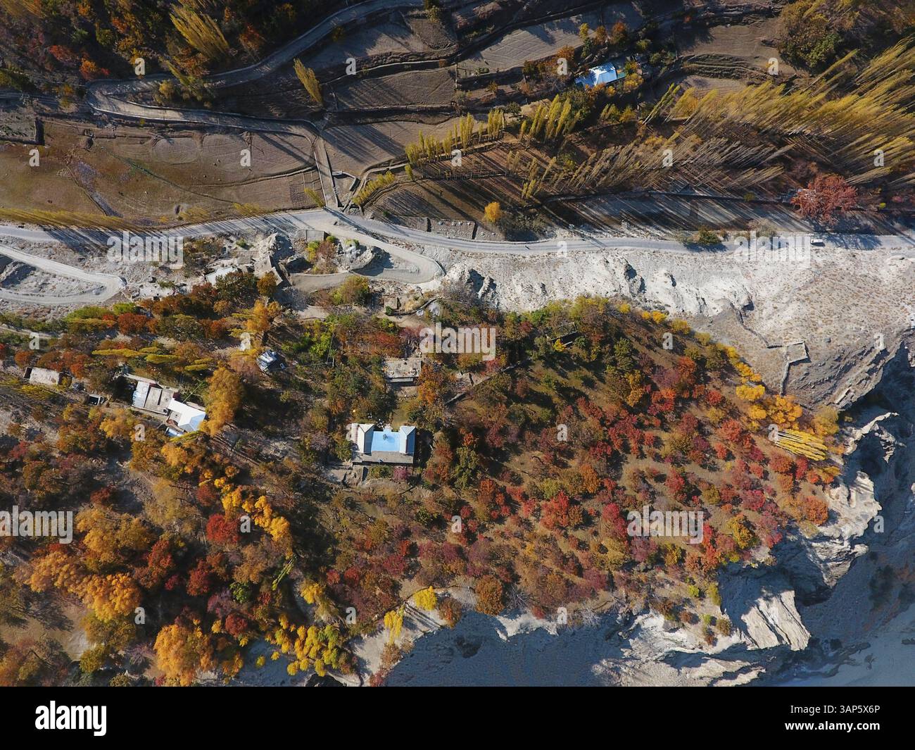 Aerial view of remote village with forest, houses, road, cliff, and ...