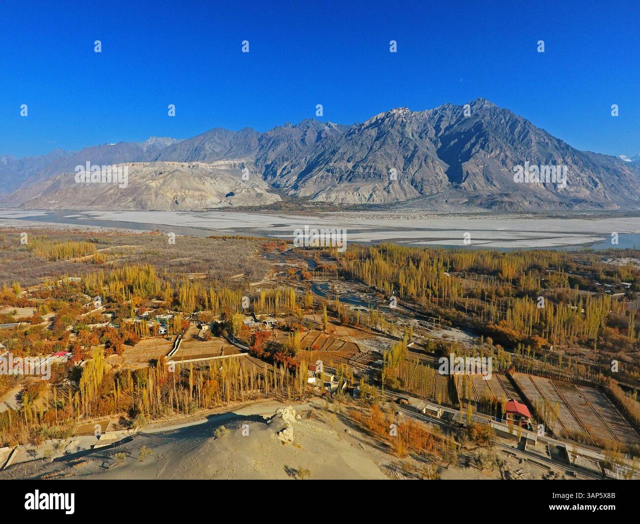 Aerial view of majestic Himalayas and remote village in Hunza Valley ...