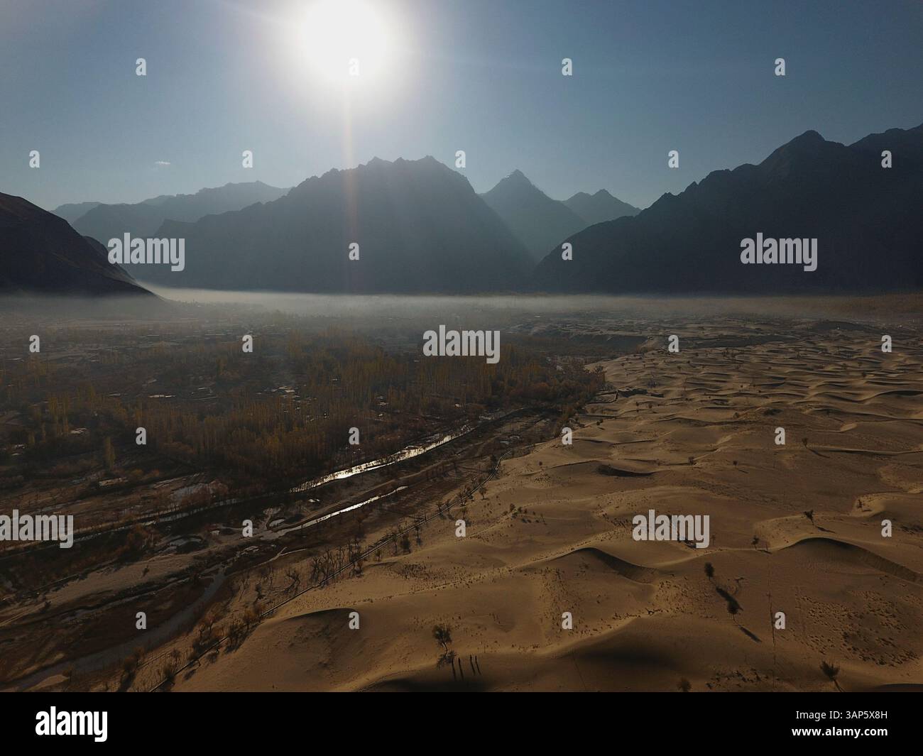 Aerial view of Katpana Desert at sunset with sand dunes and mountains ...