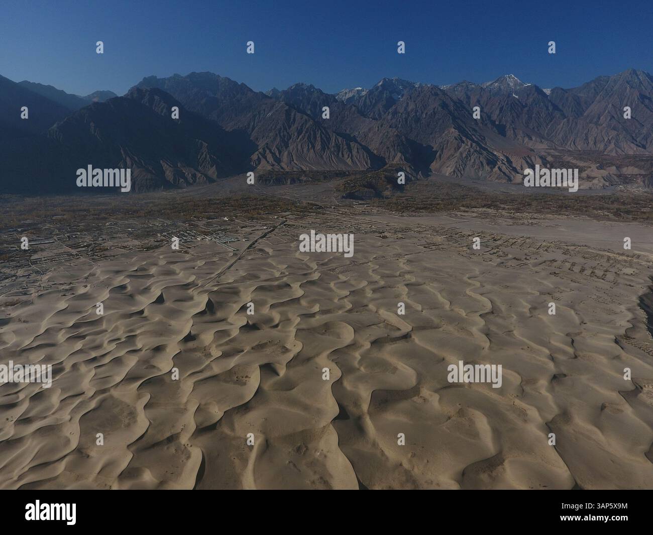 Aerial view of Katpana Desert with majestic mountains and sand dunes ...