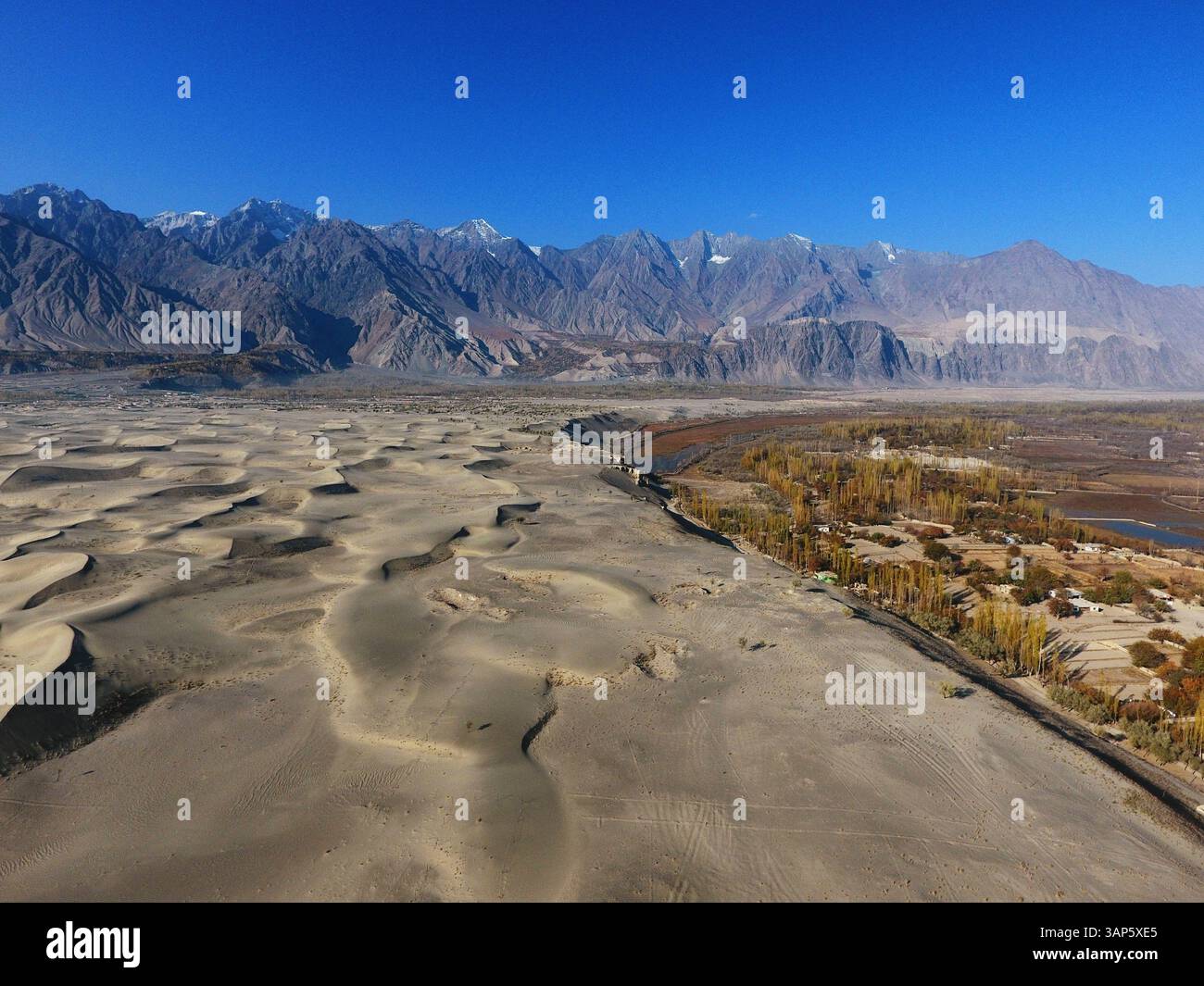 Aerial view of Katpana Desert with majestic mountains and sand dunes ...