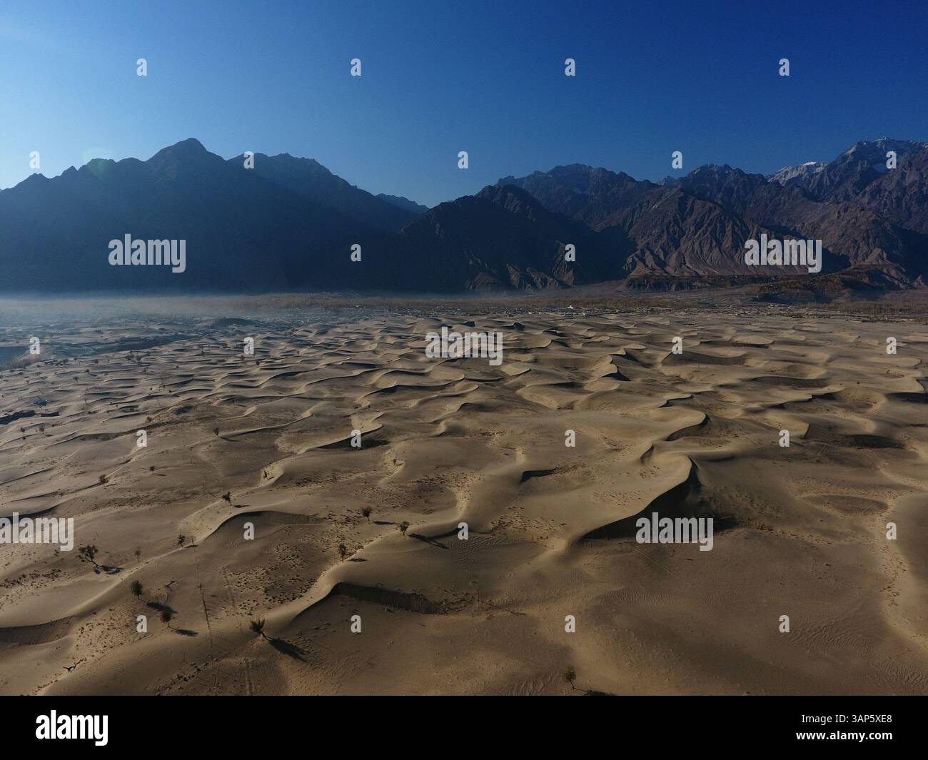 Aerial view of Katpana Desert with sand dunes and mountains, Gilgit ...