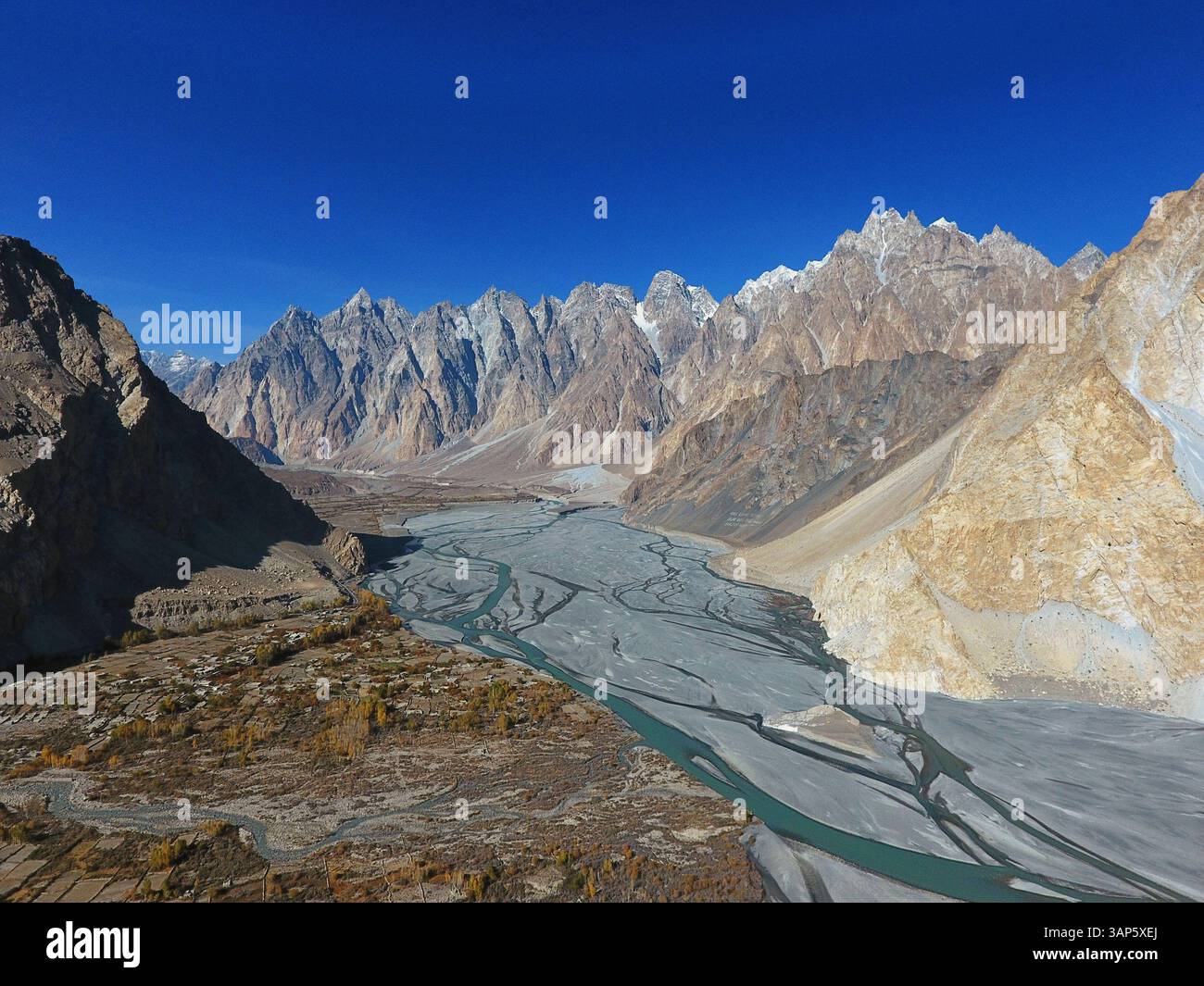 Aerial view of majestic mountains, river, valley, and road in winter ...
