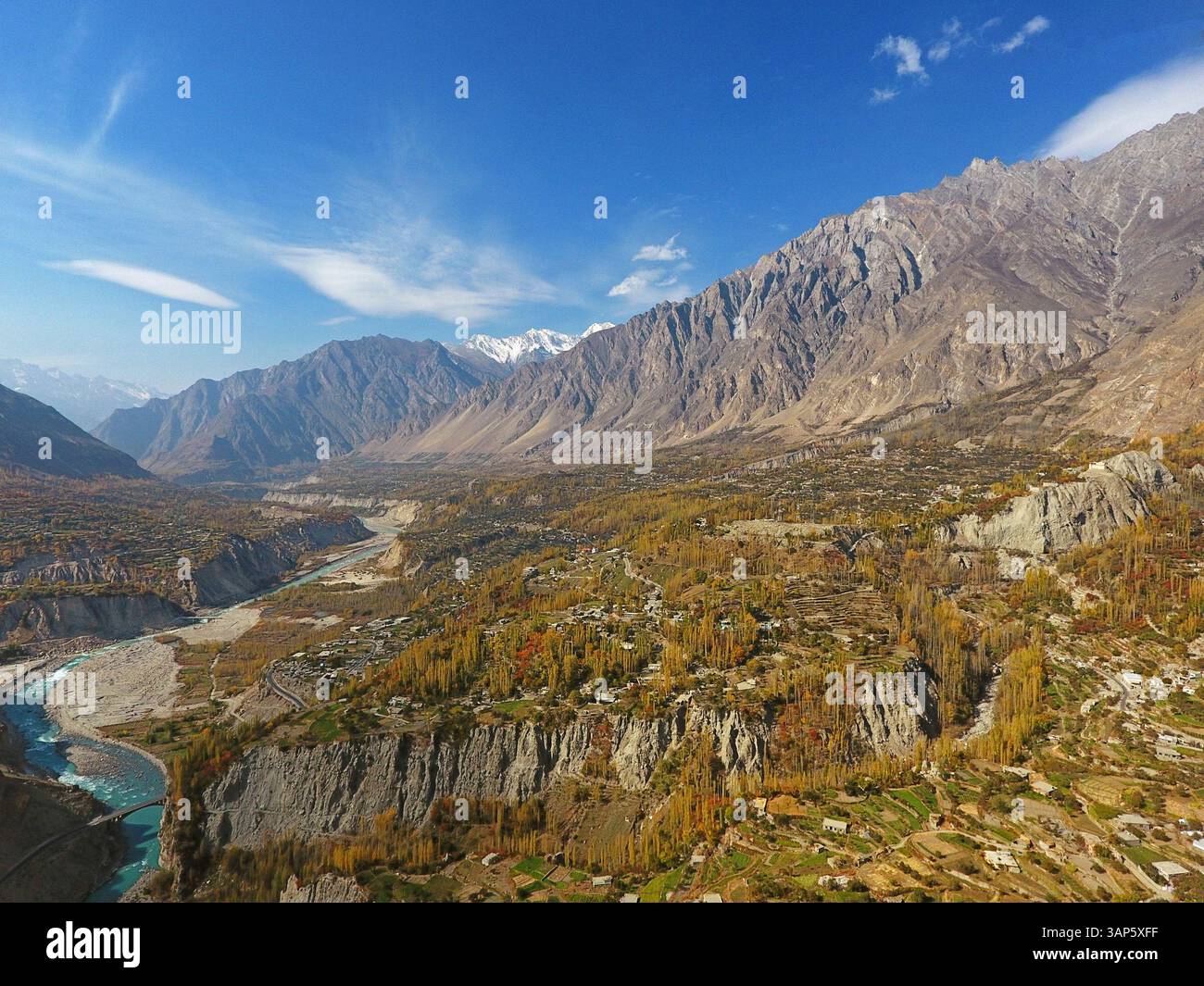 Aerial view of Majestic Hopar Valley with river, cliffs, and snow ...