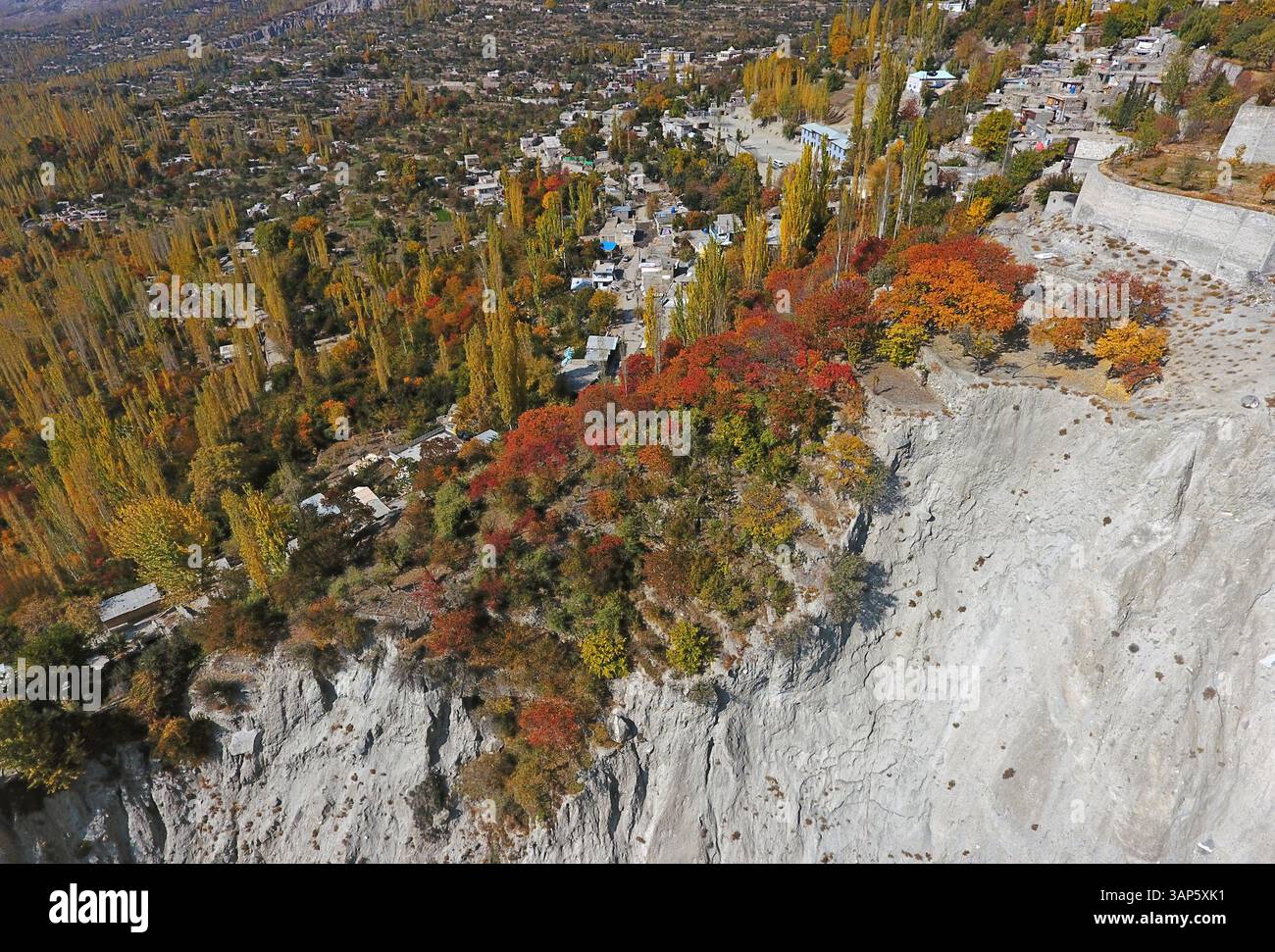 Aerial view of colorful autumn village nestled in forested cliff, Hopar ...