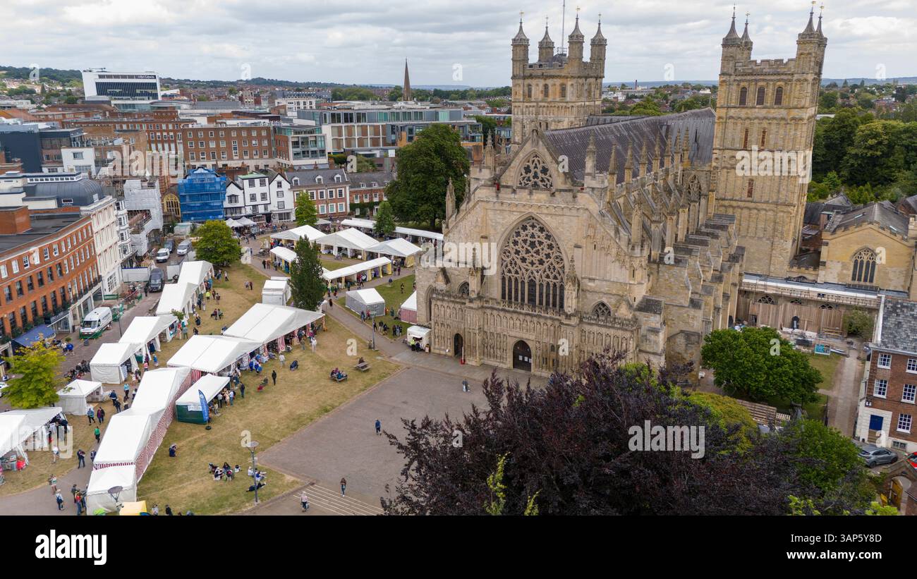 Aerial view of bustling exeter cathedral surrounded by tents and people ...
