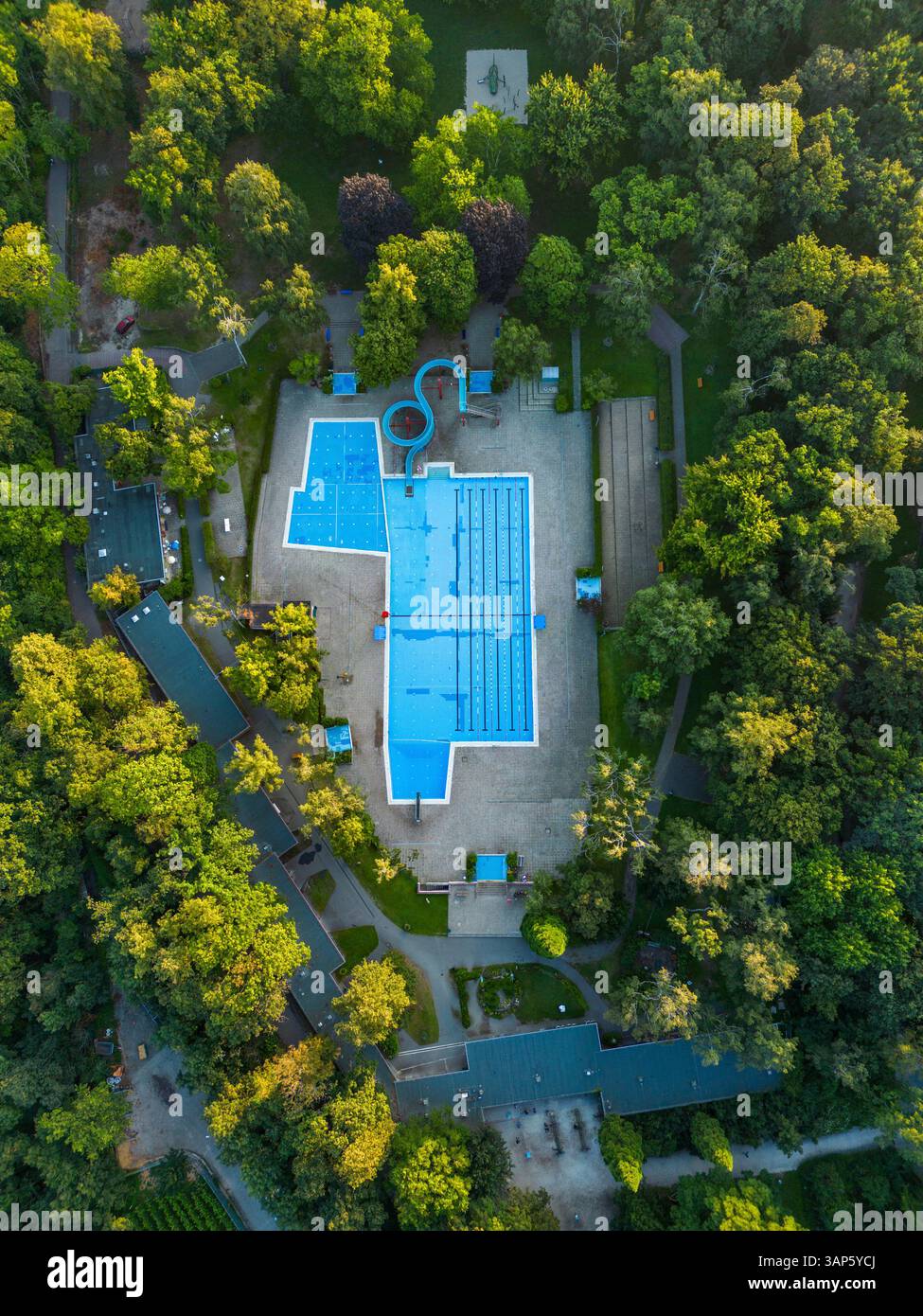 Aerial view of a beautiful public swimming pool surrounded by lush ...