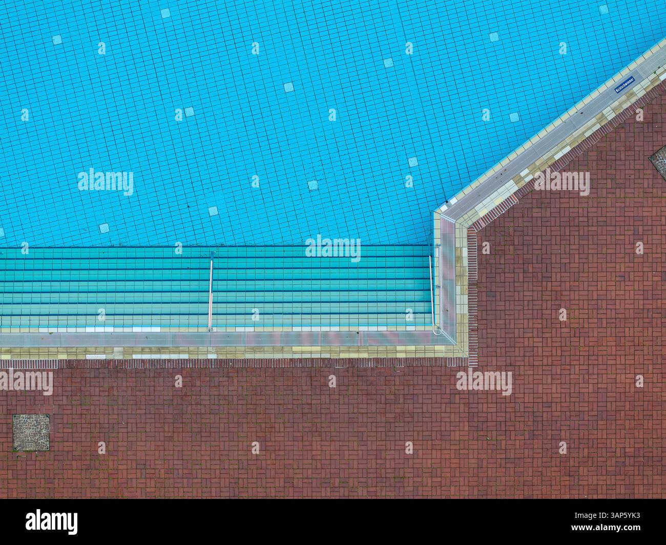 Aerial view of a geometric public pool with blue tiles and clean water ...